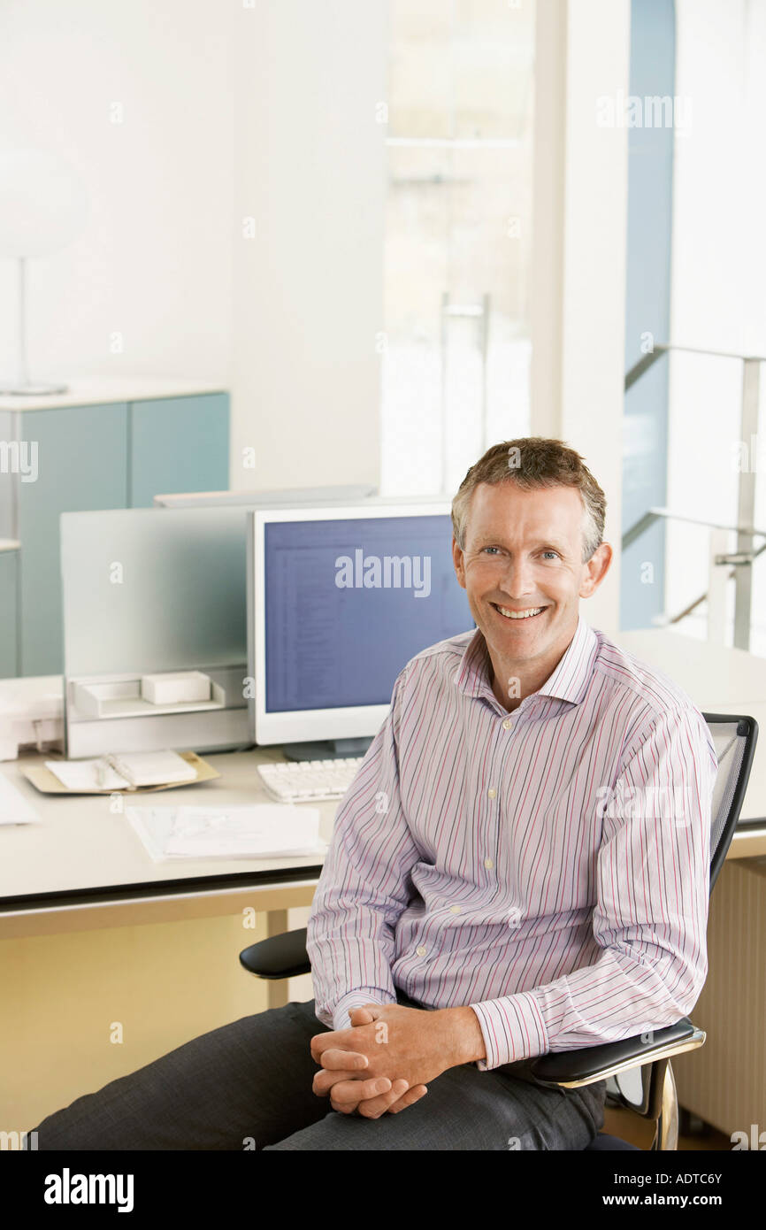 Middle-aged male office worker sitting in cubicle, portrait Stock Photo - Alamy