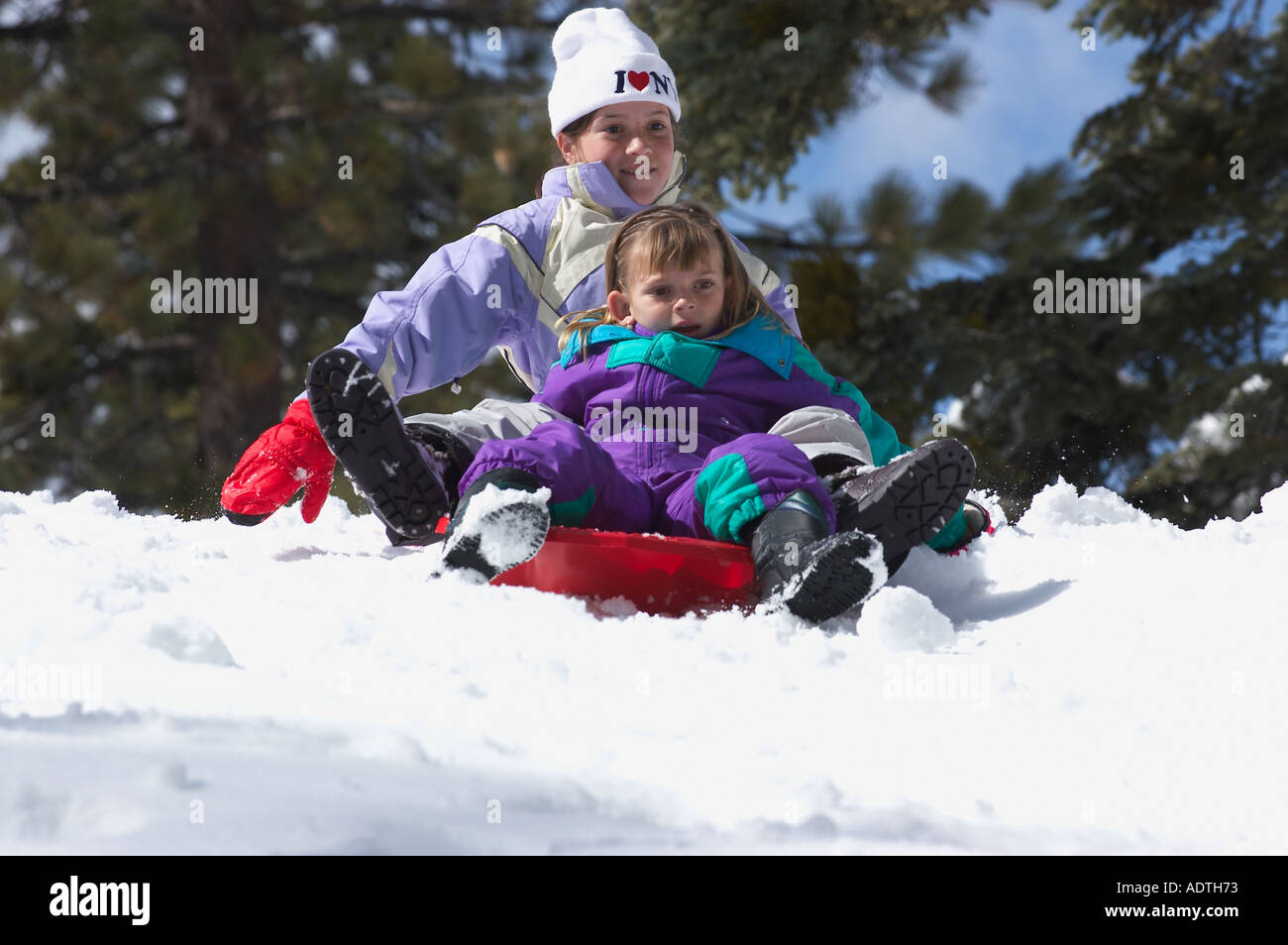 girls on snow sled Stock Photo - Alamy