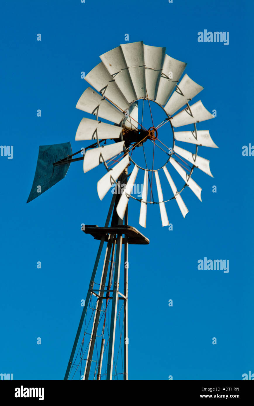 Old fashioned windmill pumping water with wind energy Stock Photo - Alamy