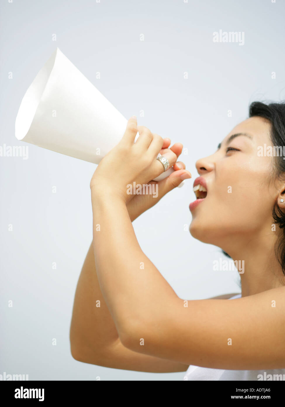 Side profile of a young woman yelling into a megaphone Stock Photo - Alamy