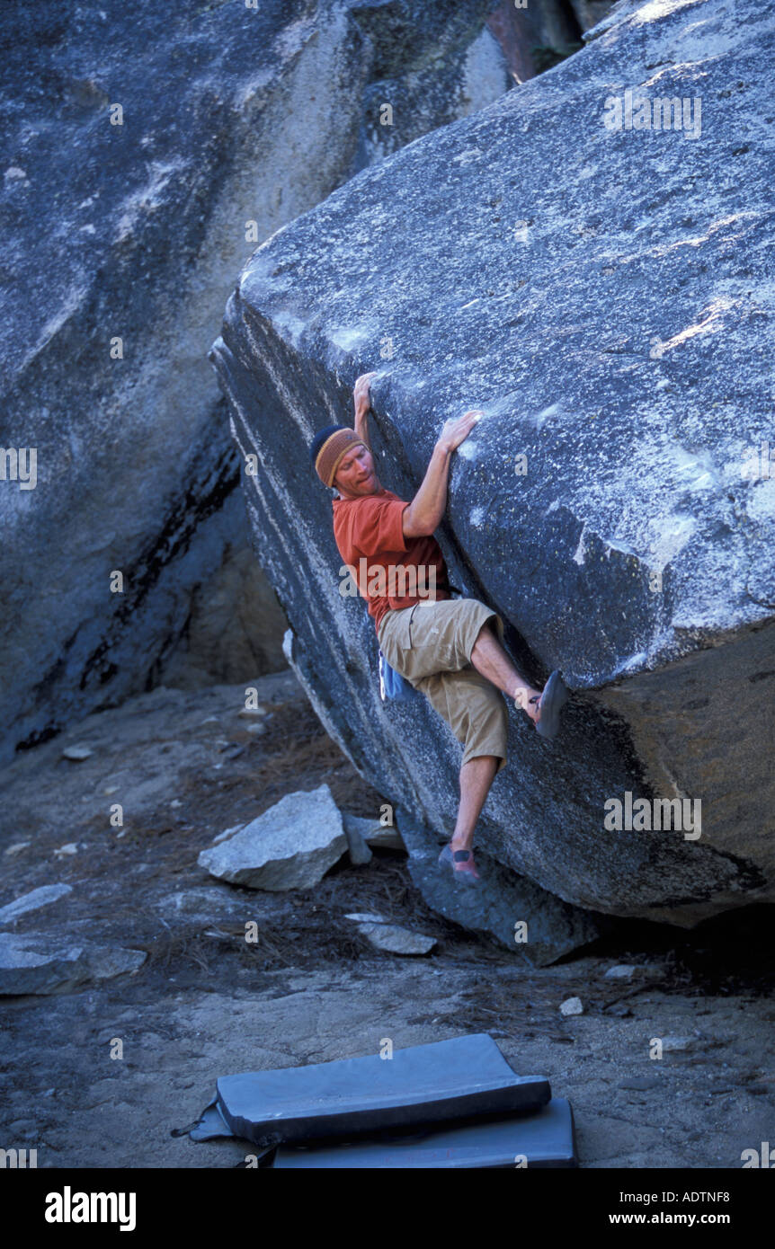 Male rock climber ascending steep boulder Stock Photo - Alamy