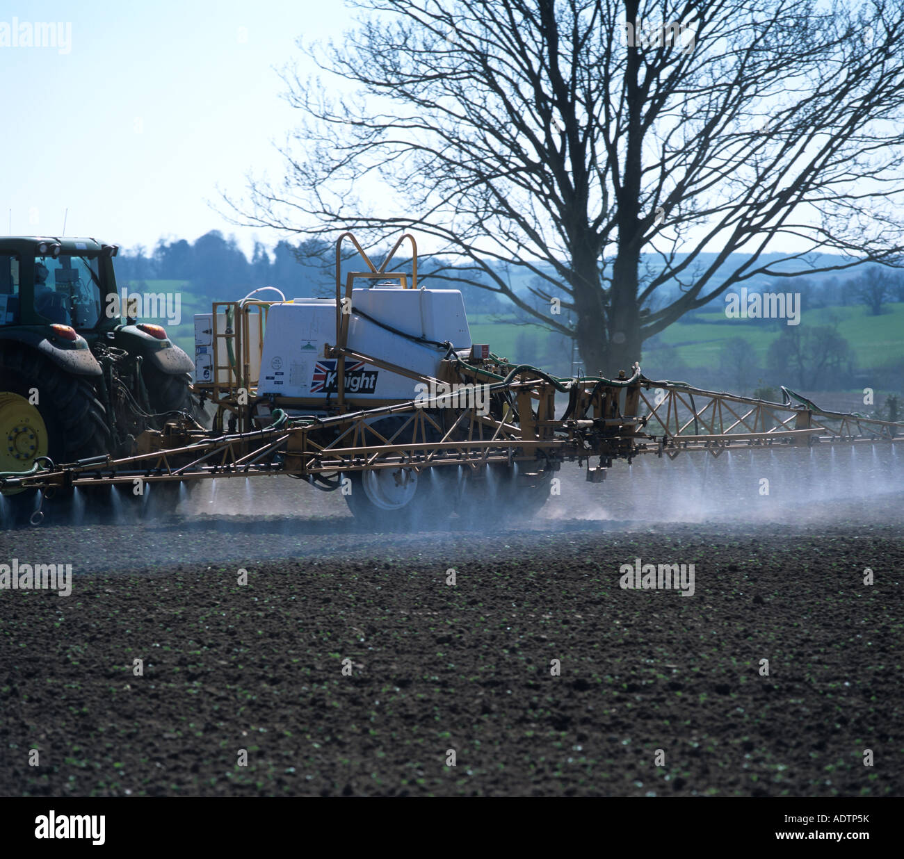 Spraying very young field bean crop with boom sprayer Devon Stock Photo ...