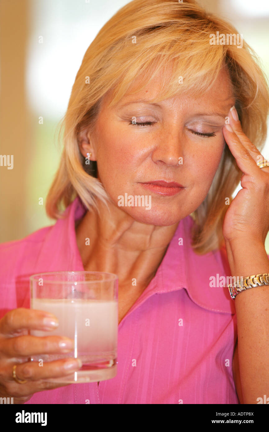 Mature Woman Feeling Unwell With A Headache Taking Soluble Painkilling ...