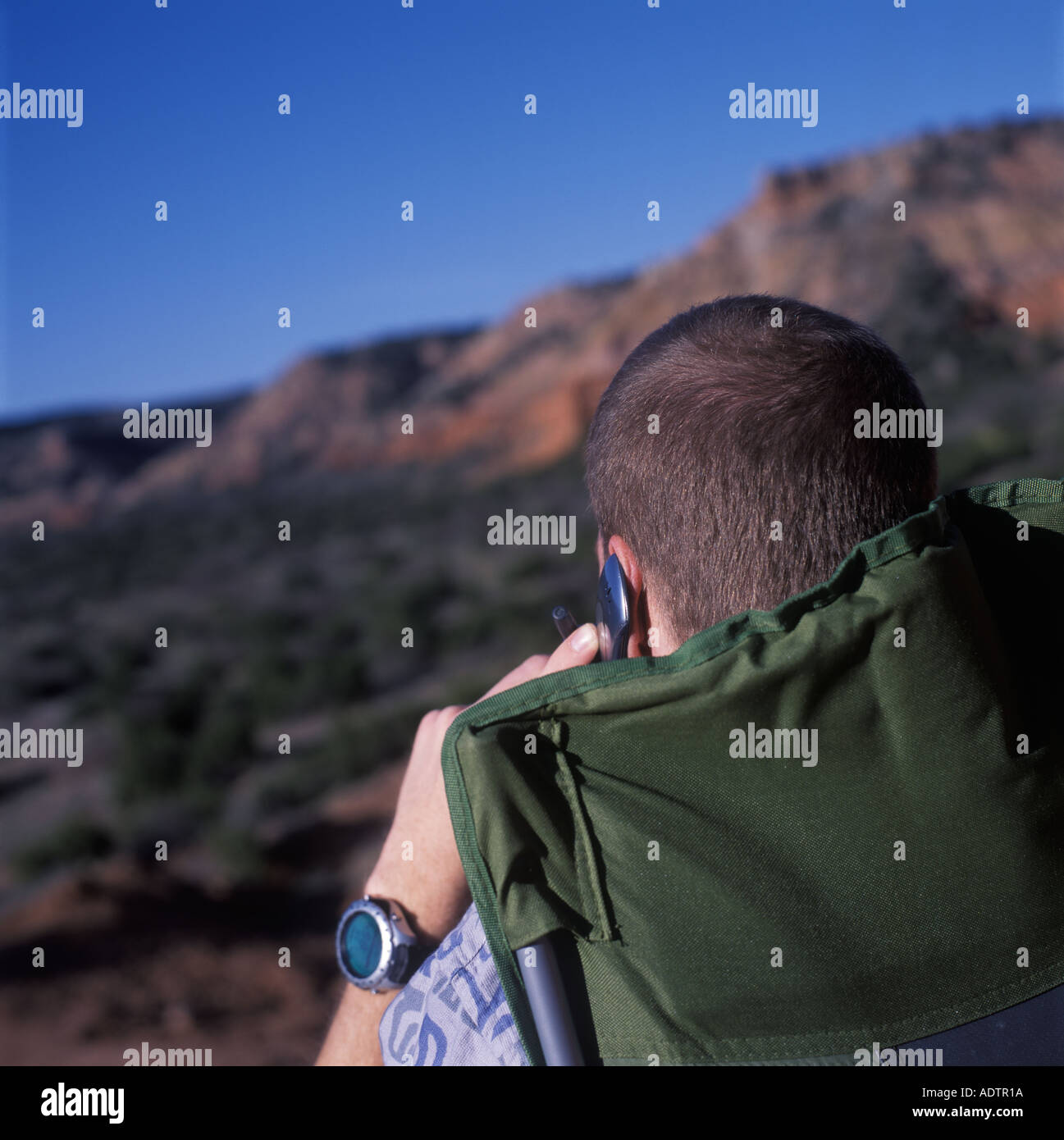 Man making a cell phone call and checking reception while camping in ...
