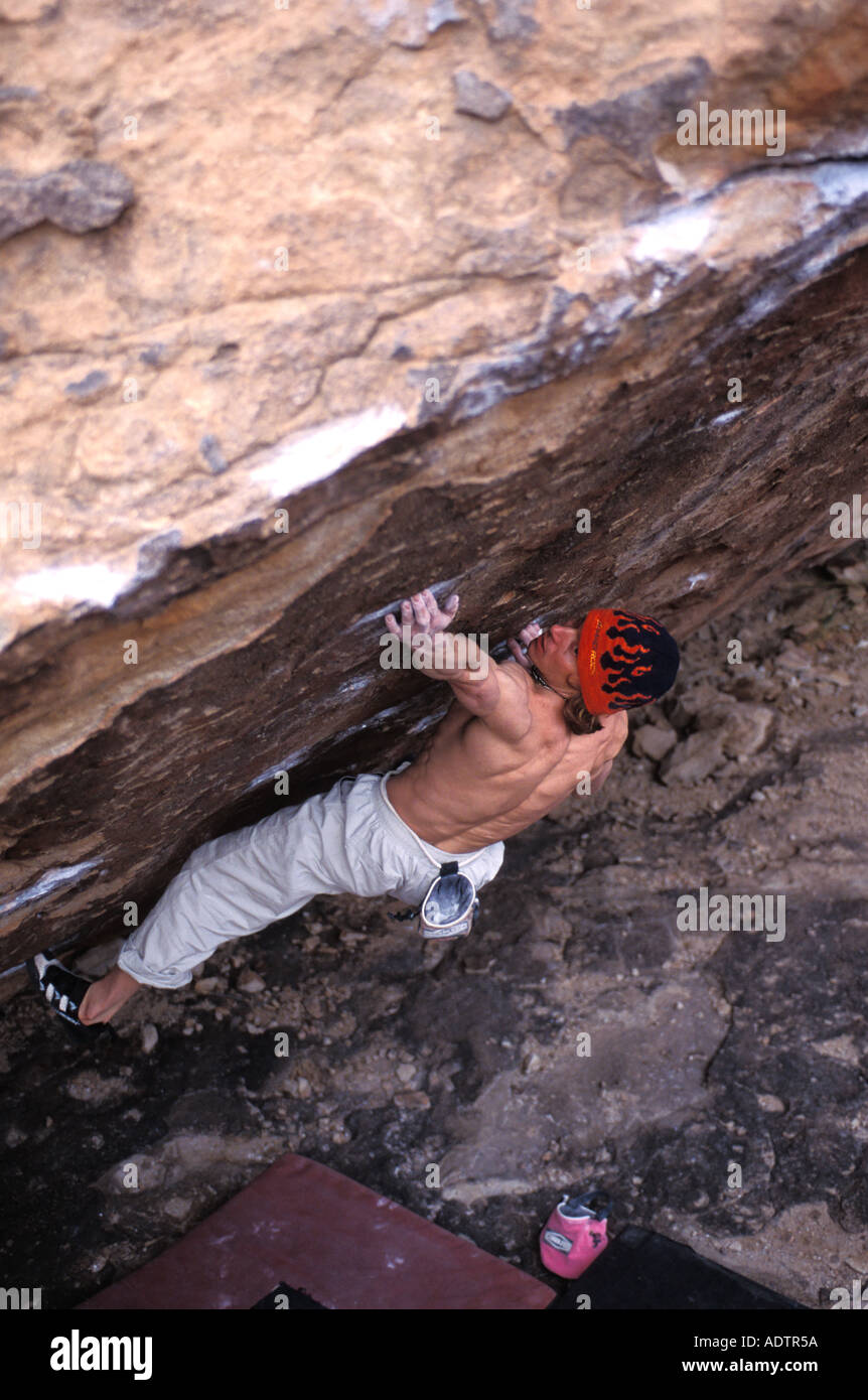 Male rock climber climbing on a steep boulder Stock Photo - Alamy