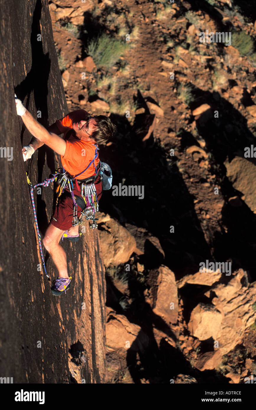 Male rock climber climbing difficult crack climb in the desert ...