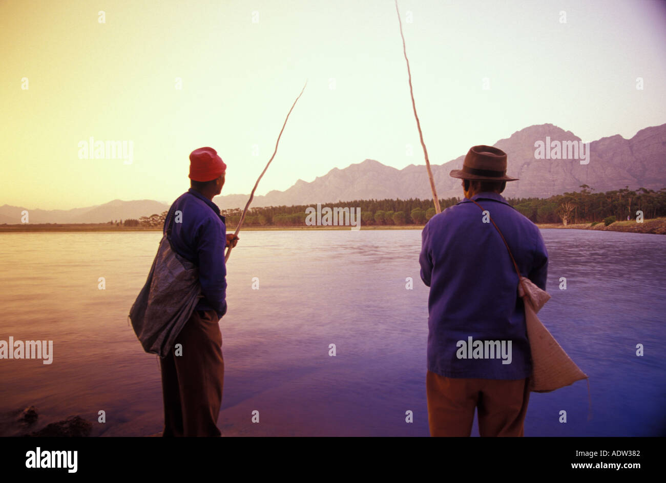 Fishermen fishing in lake, rear view Stock Photo - Alamy