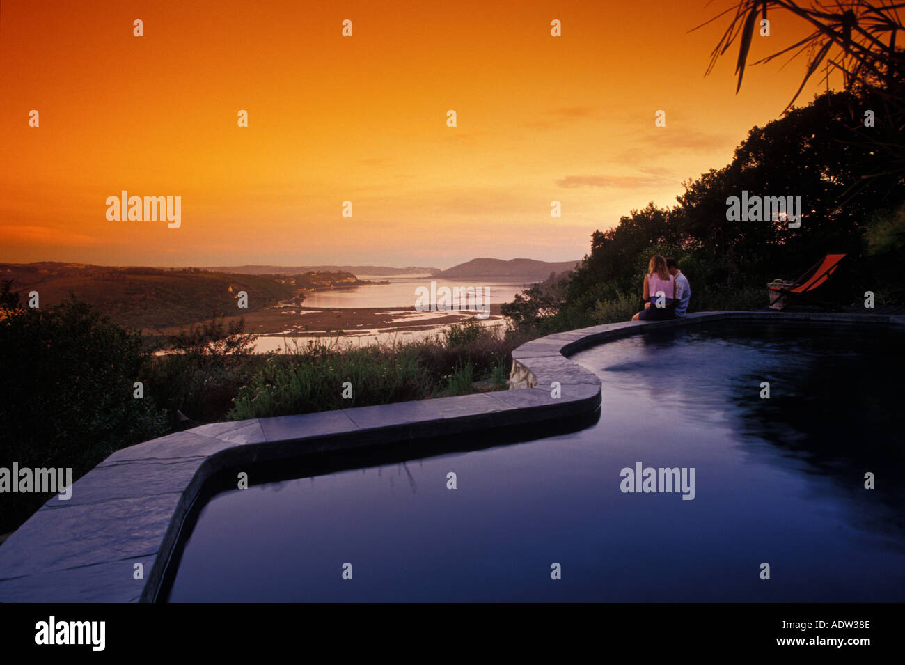 Two couples sitting by swimming pool hi-res stock photography and ...