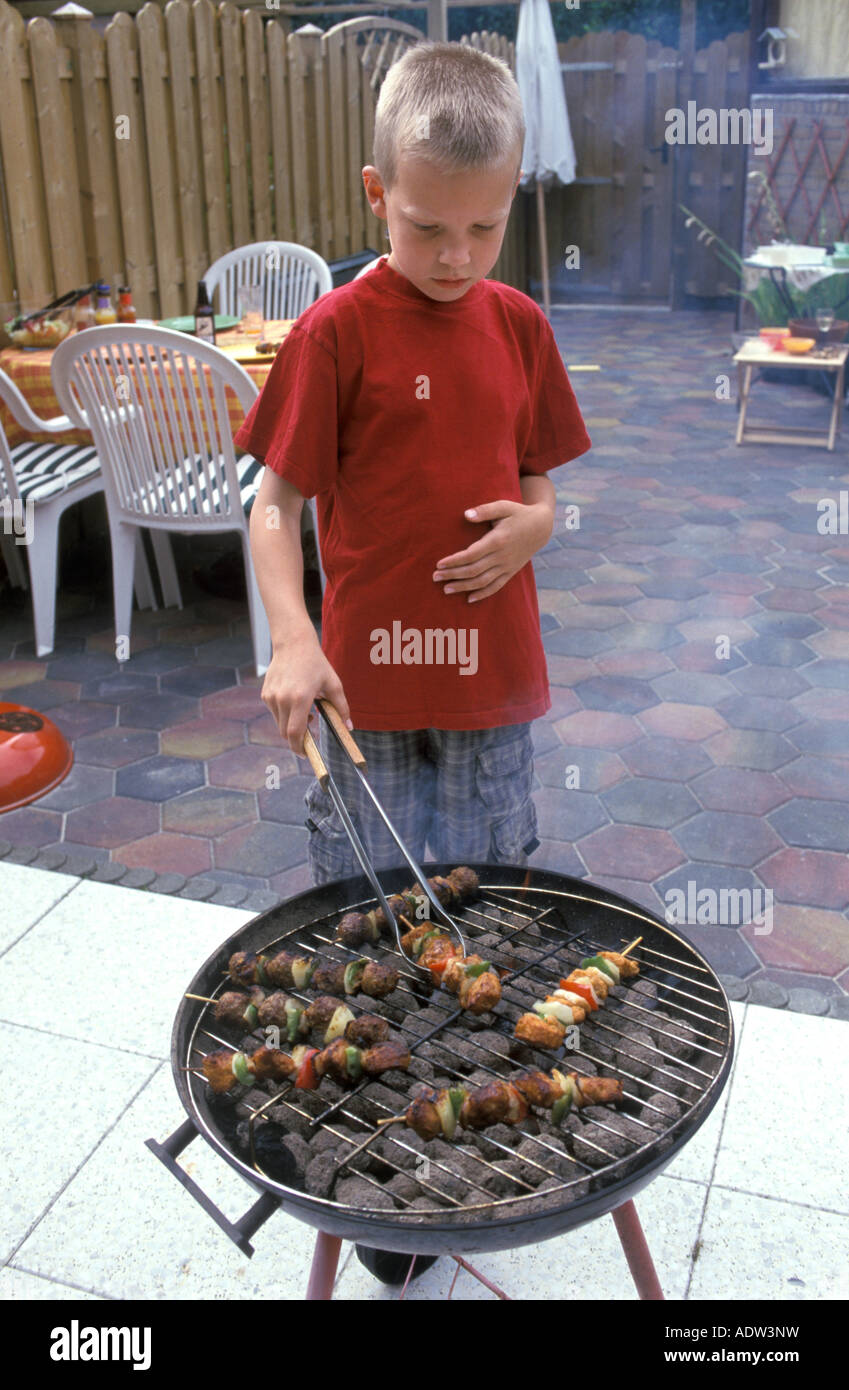 Little boy with a barbecue in the garden Stock Photo - Alamy