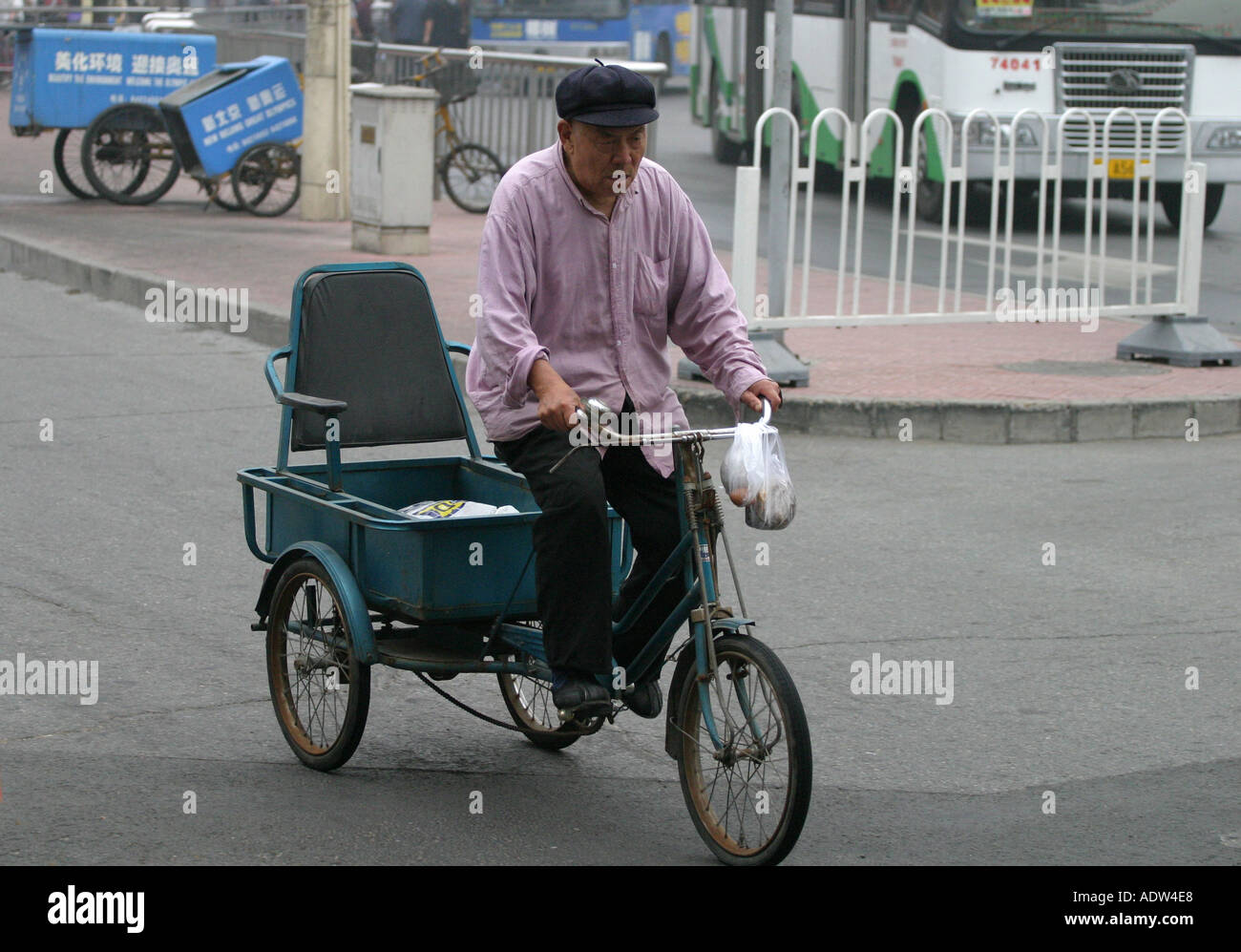 Chinese man rides a three wheeled bicycle through the smog laiden ...