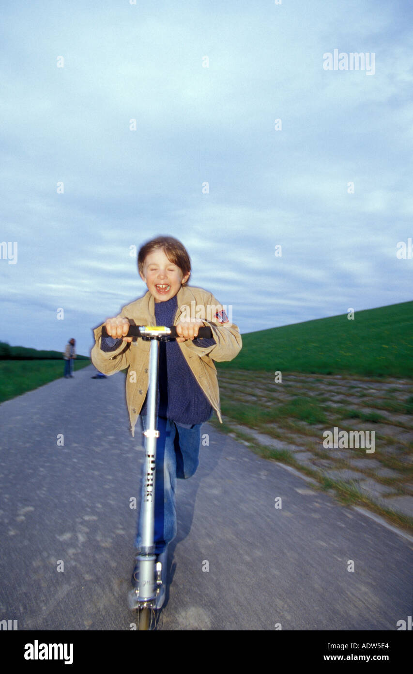 Boy riding scooter Stock Photo - Alamy