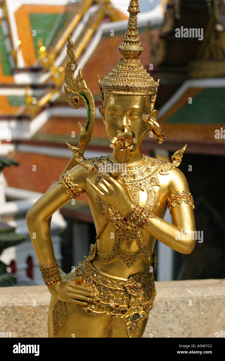 Golden guardian statue stands in front of the colourful Grand Palace ...