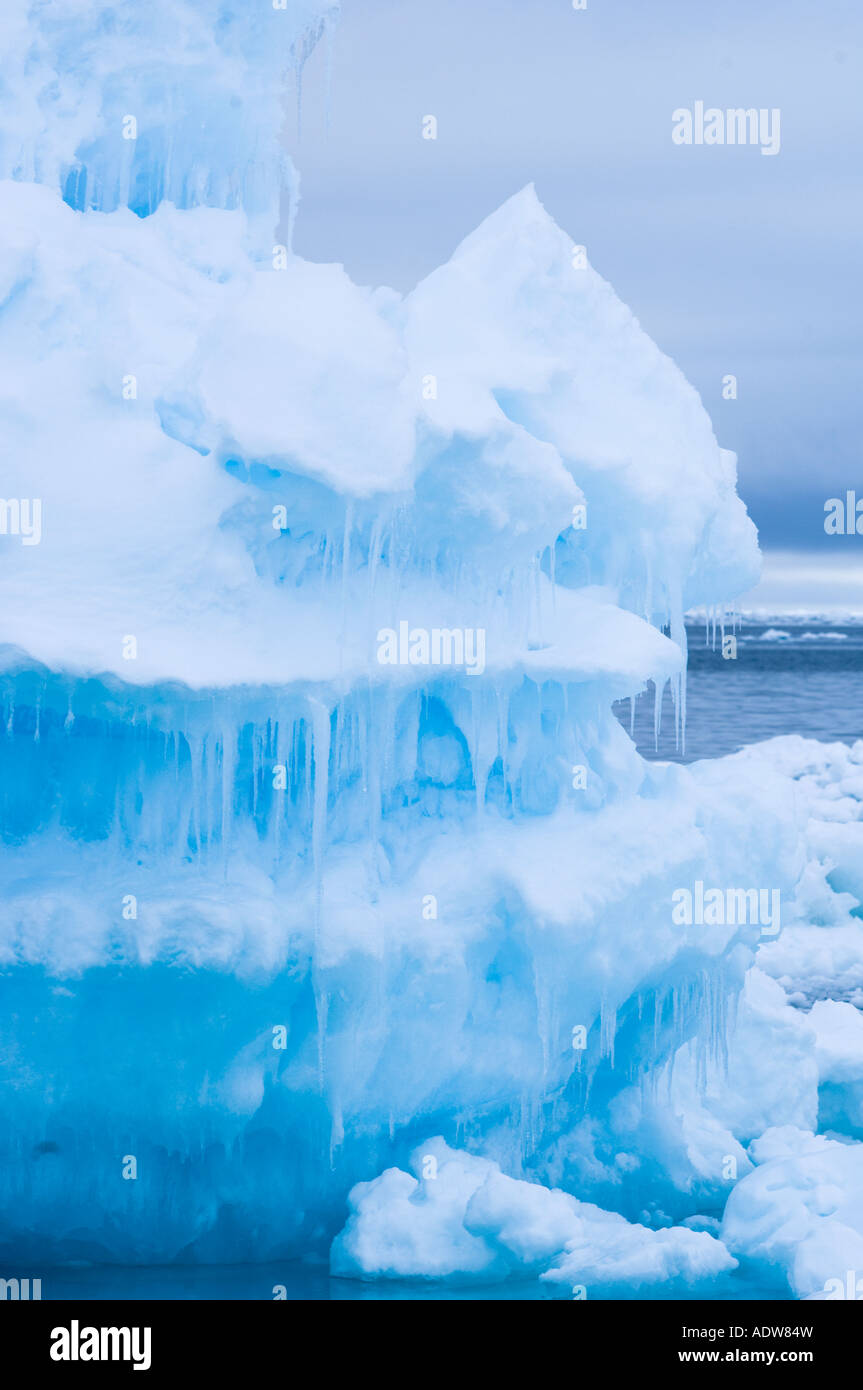 Iceberg floating in moving pack ice. Icicles form as the ice melts in ...