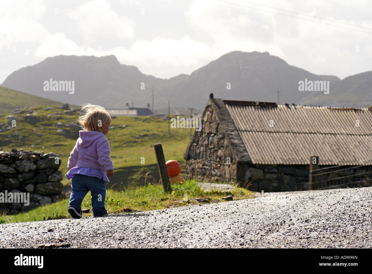 Young girl (18 months old) walking on croft path, Uig, Isle of Lewis ...