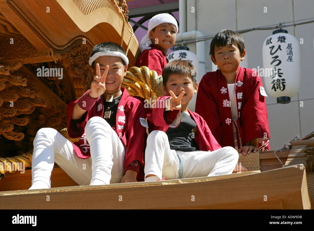 Young Japanese children play on the roof of a wooden festival float ...