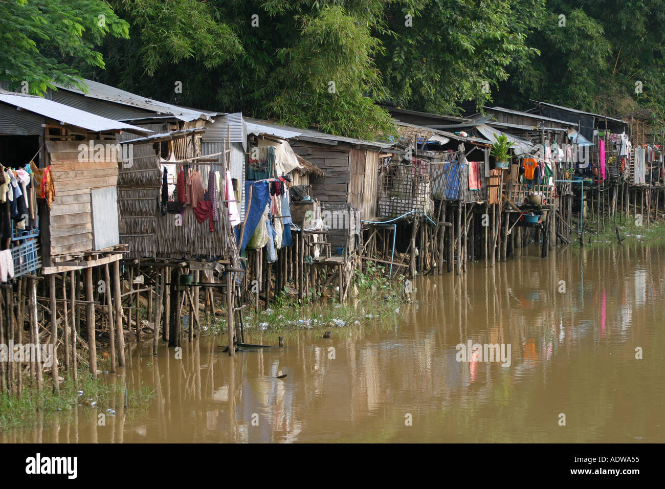 Wooden huts with drying washing on the river in Siem Reap Cambodia show ...