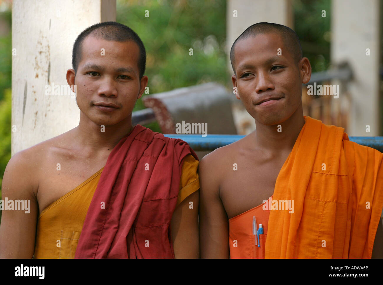 Two young Cambodian buddhist monks in yellow robes pose for a photo at ...