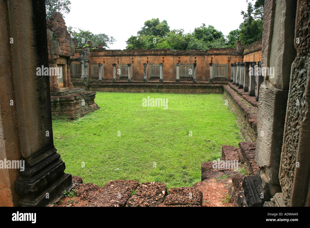 Lush green grass grows in the ancient Cambodian temple of Pre Rup Siem ...