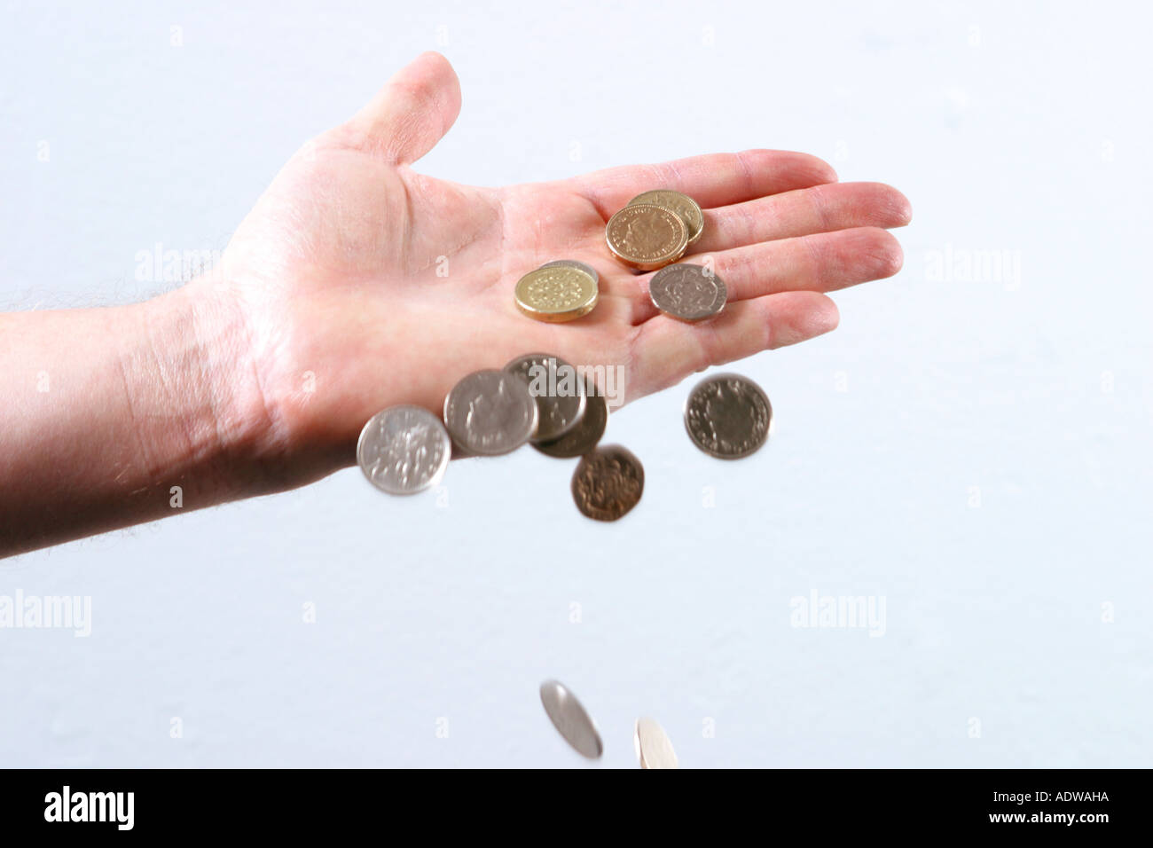 Coins falling from an open hand Stock Photo - Alamy