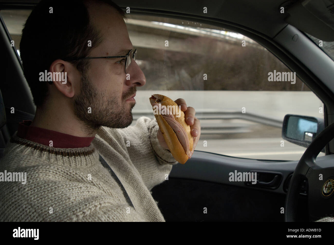man, eating when driving Stock Photo - Alamy