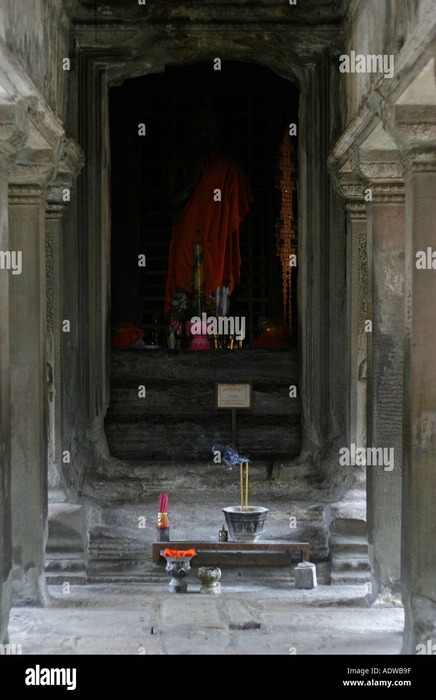 Dark buddhist altar inside the ancient stone walls of Angkor Wat temple ...