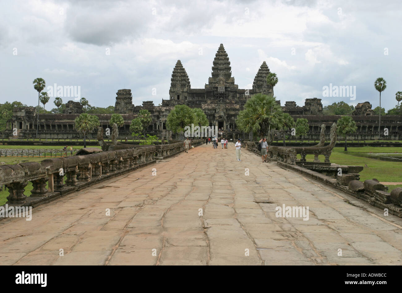 Tourists on the pathway leading up to the main Angkor Wat temple Angkor ...