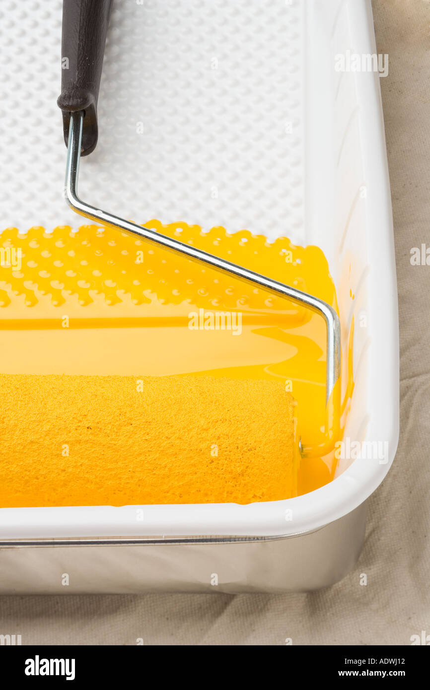 Still life of paint roller with yellow paint Stock Photo - Alamy
