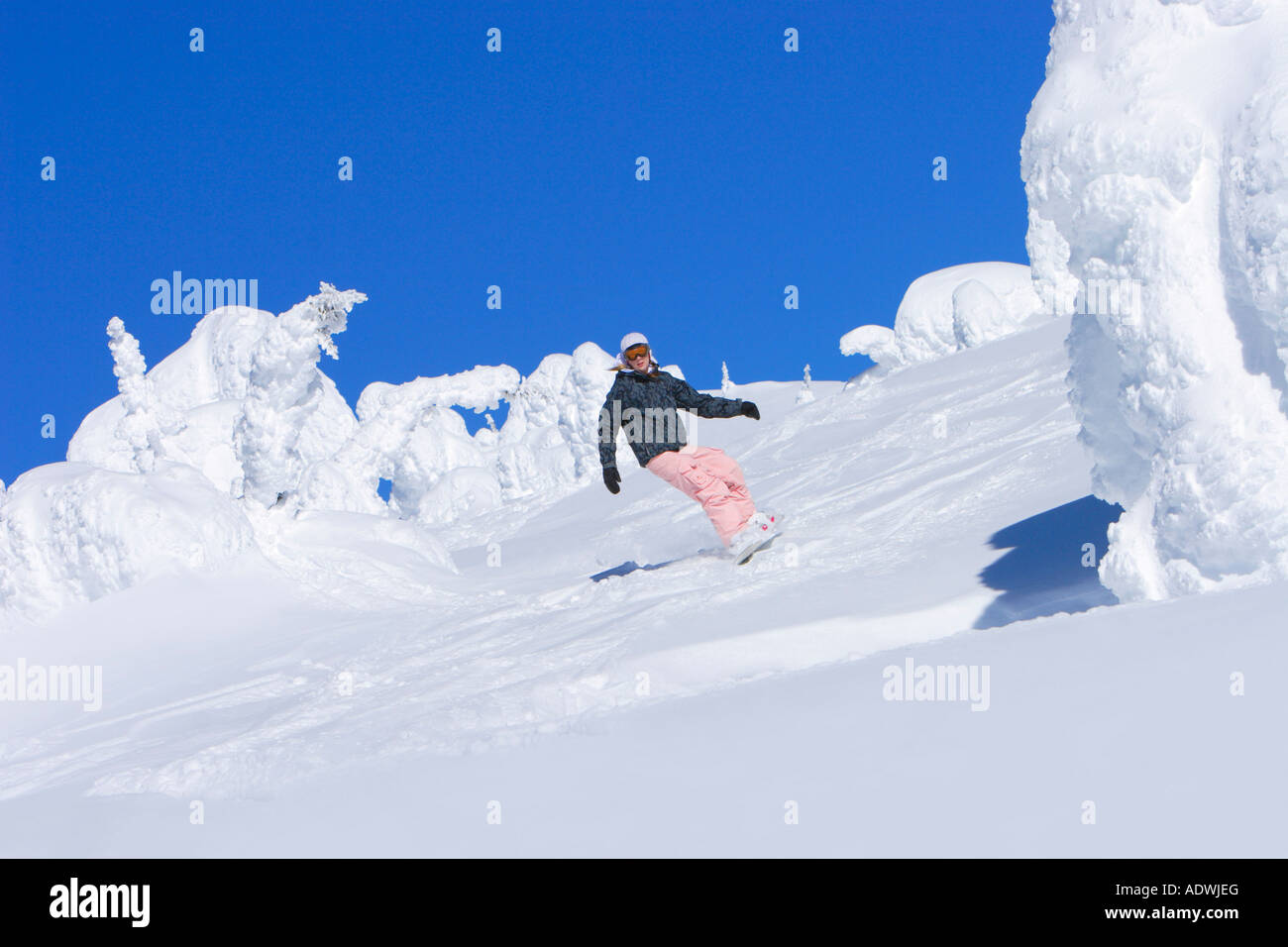 Snowboarder carving down slope Stock Photo - Alamy