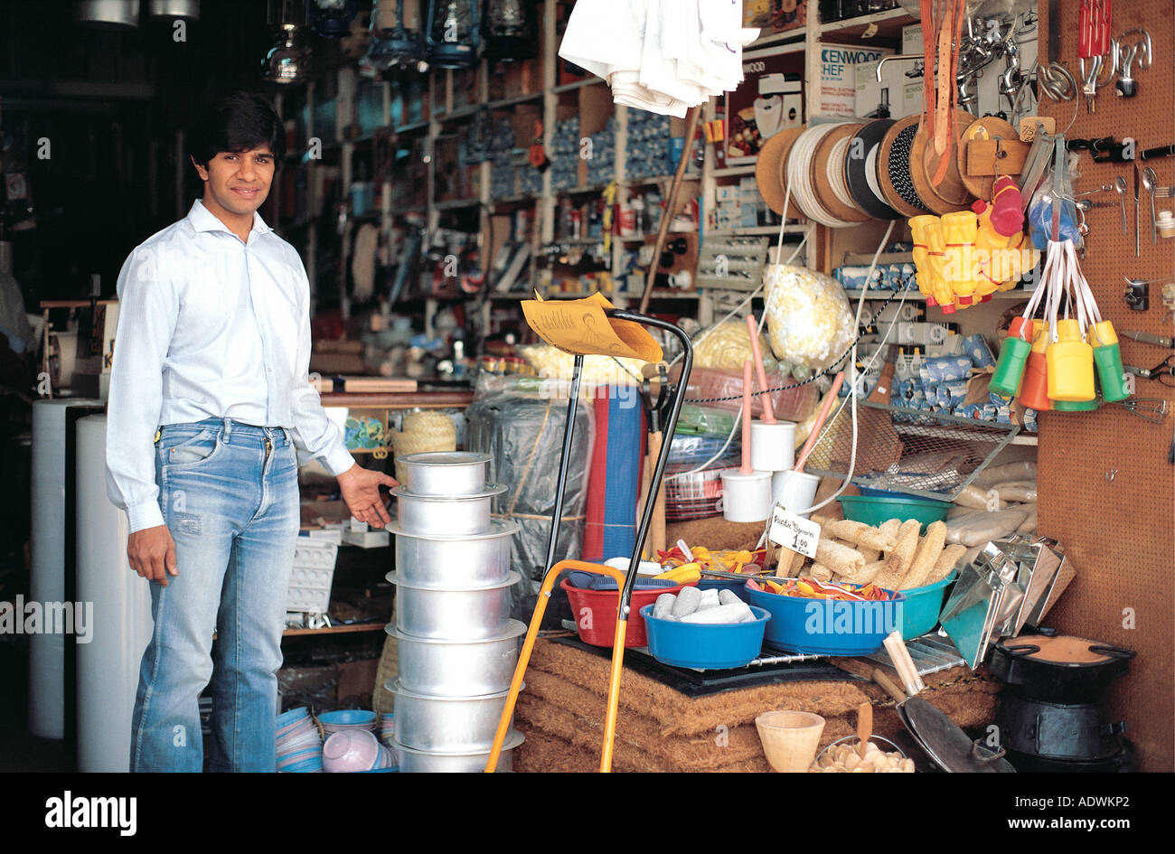 Young Asian or east Indian shopkeeper at the entrance to his Hardware ...
