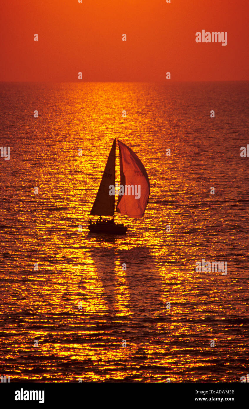 Single Sailing yacht boat creates a shadow from the setting sun Ischia ...