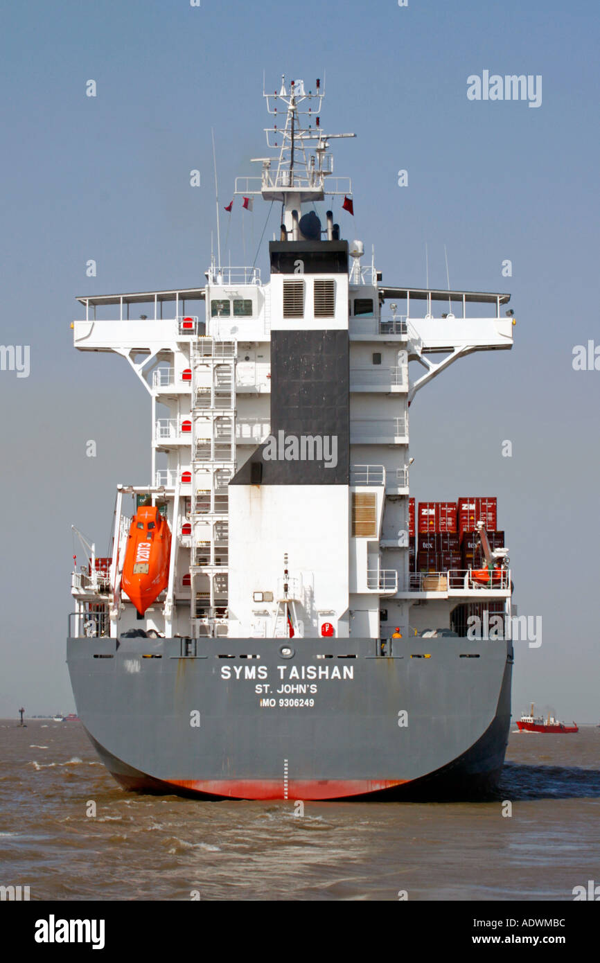 A cargo ship full of containers heads to sea from the Huang Pu river in ...