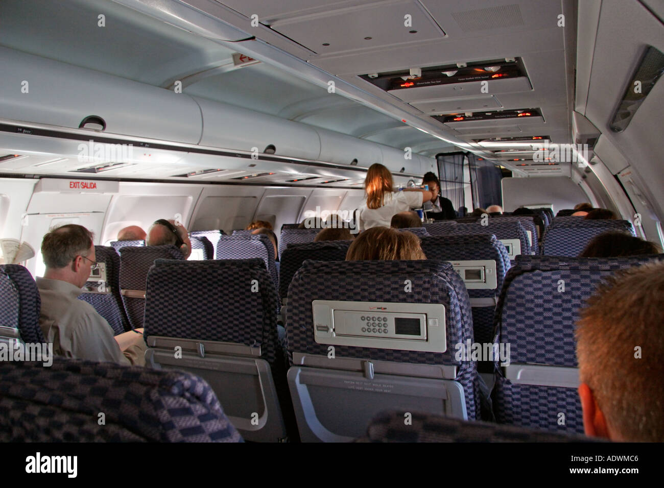 The cabin of a 727 airplane during flight Includes rear view of many ...