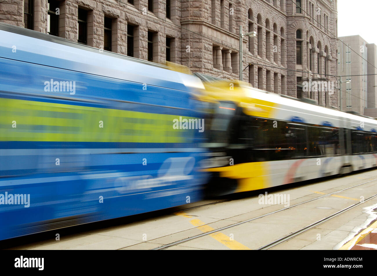a light rail mass transit train speeds past the government plaza ...