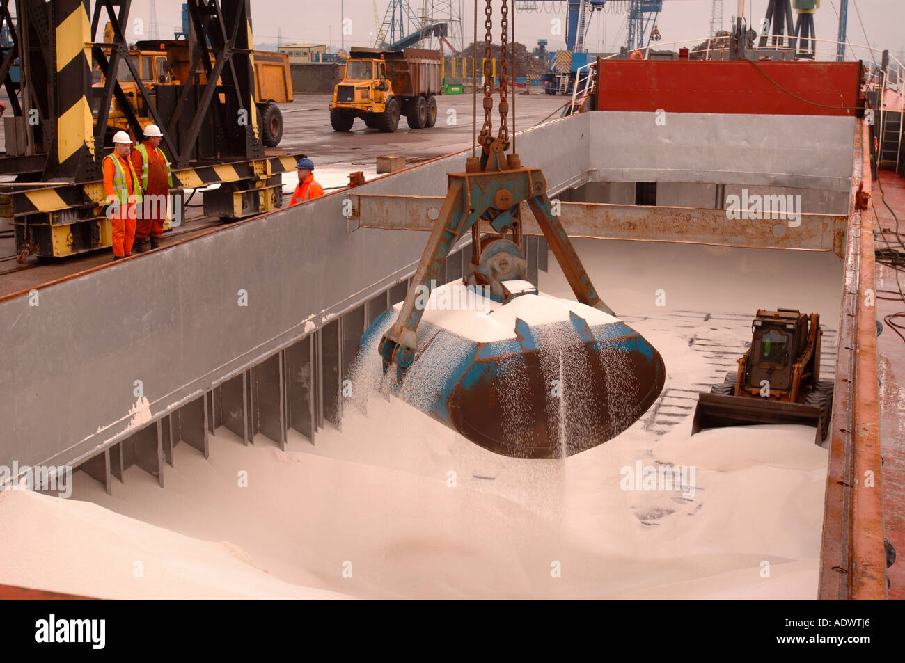 UNLOADING FERTILISER BY CRANE ON THE DOCKSIDE AT A PORT IN NEWPORT ...
