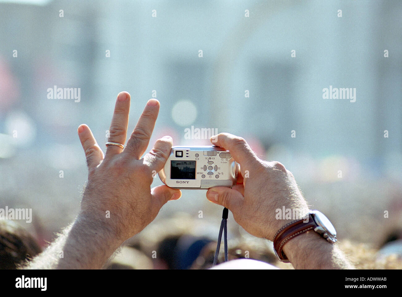 detail of man taking picture with digital camera in crowd Stock Photo ...