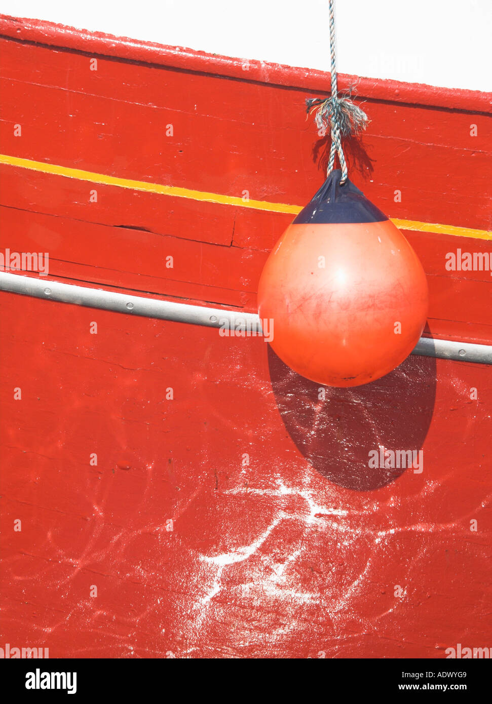 Bouy hanging beside the hull of a red fishing boat Oban Argyll and Bute ...