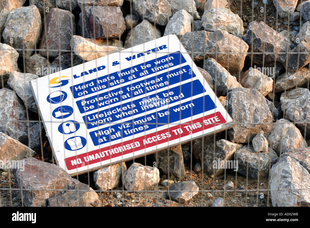 Discarded construction safety warning sign on granite rocks Stock Photo ...