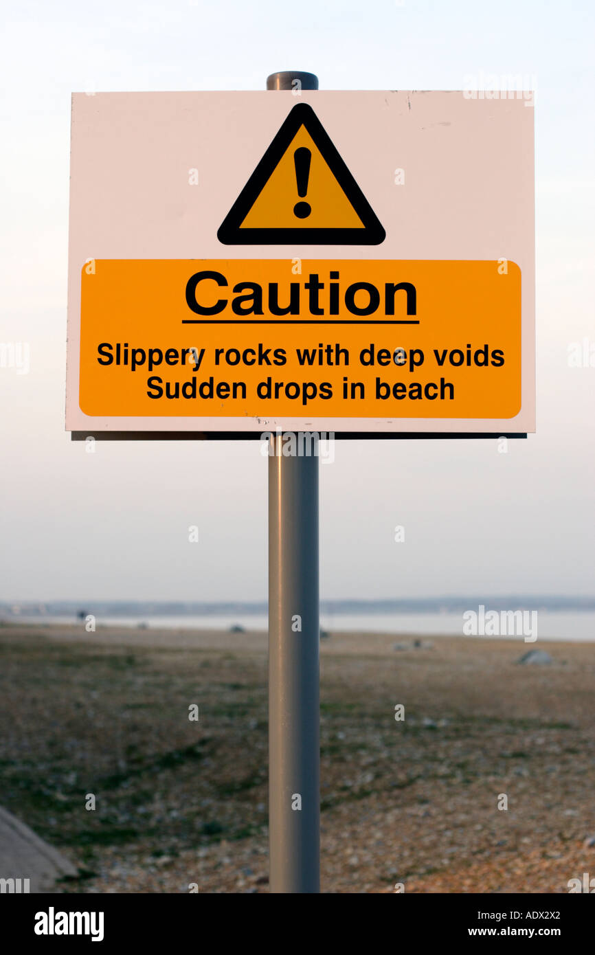 Warning sign on rocky beach Stock Photo - Alamy