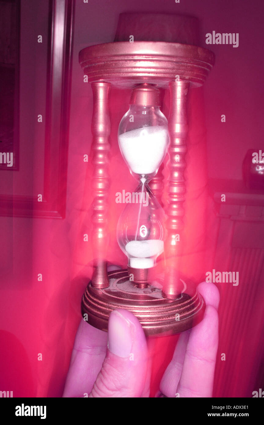 Hand holding hourglass sand hour glass passing time Stock Photo - Alamy