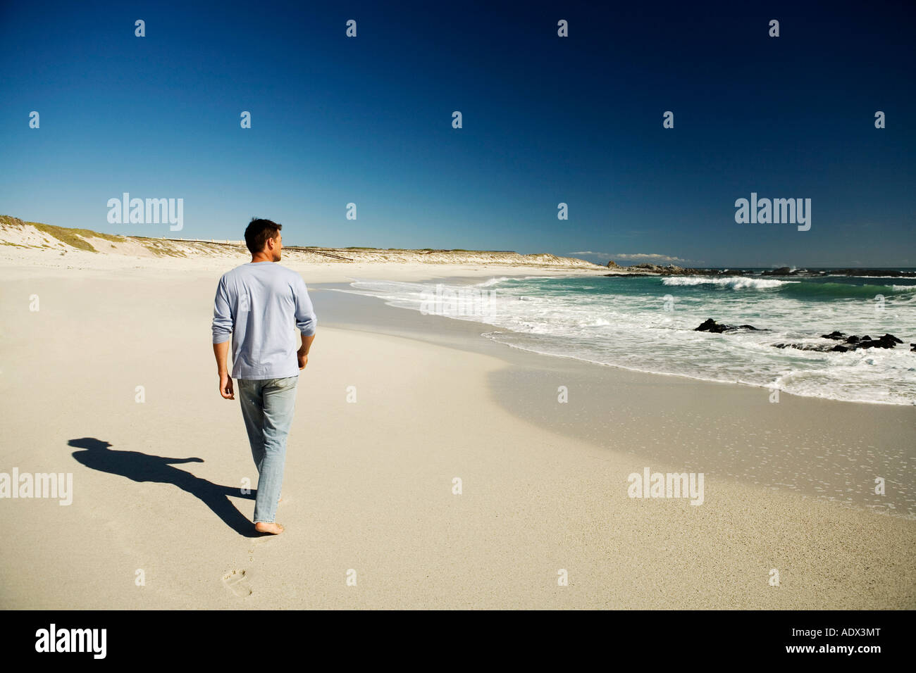 Ma walking on the beach rear view Stock Photo - Alamy