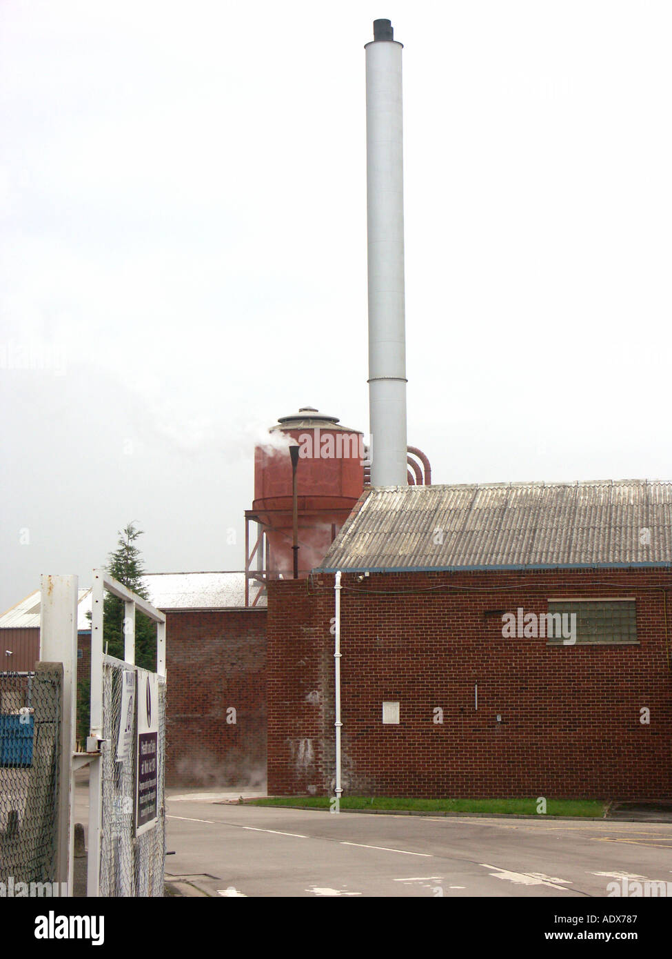 Waste steam coming from small chimney at factory Stock Photo - Alamy