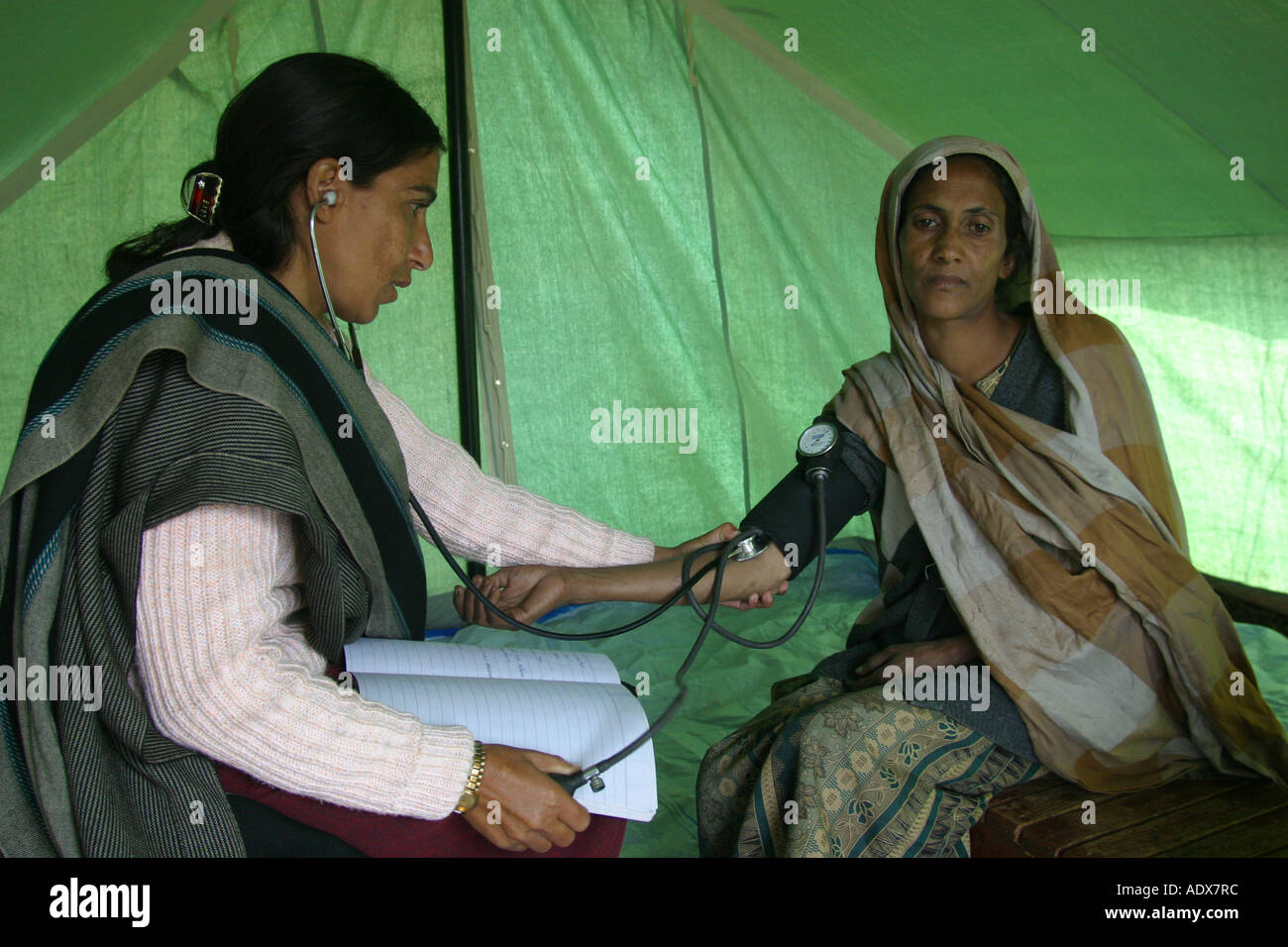 Doctor taking care of refugee woman Stock Photo - Alamy