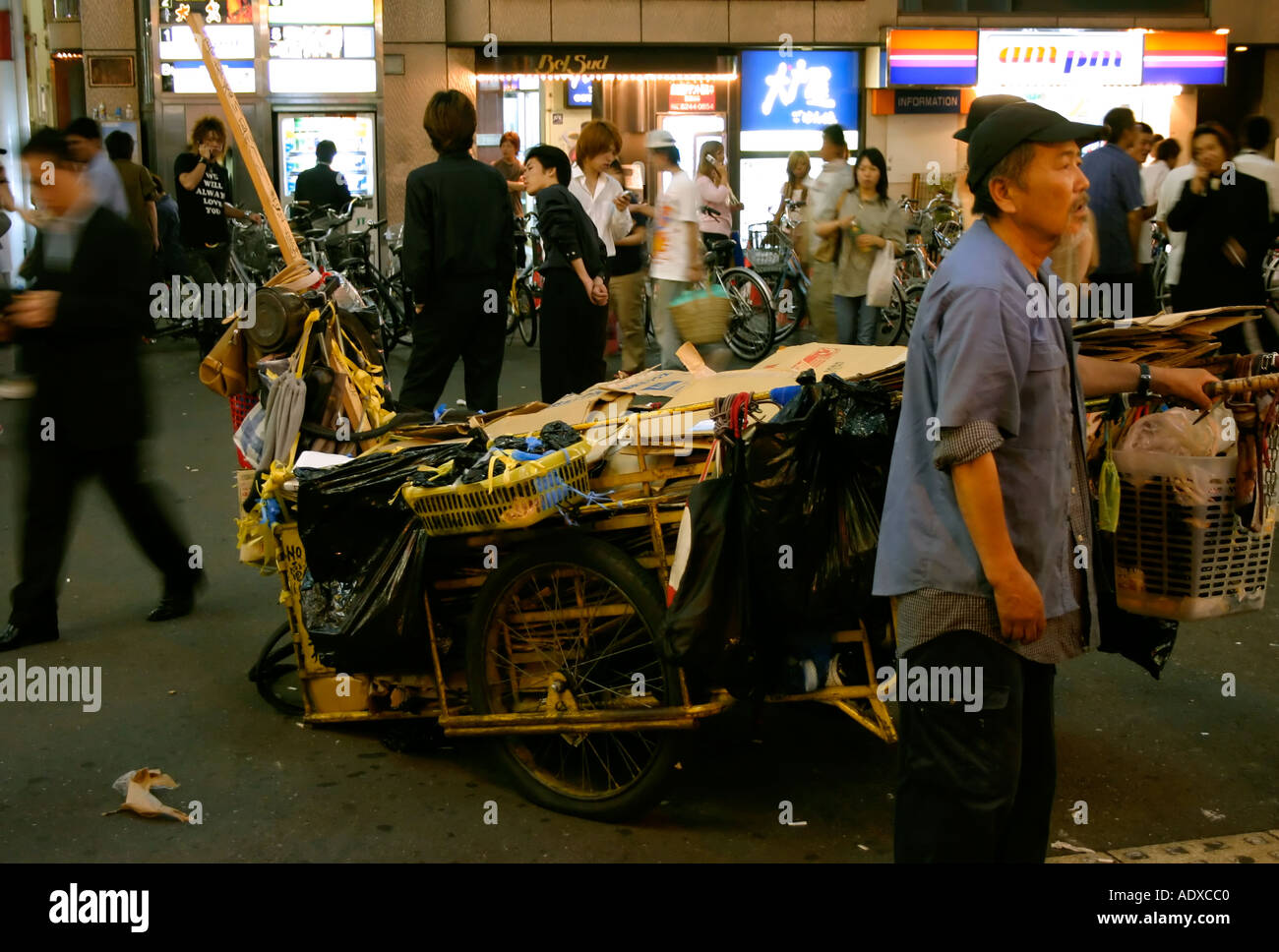 A homeless man pulling his cart of possessions through Dotombori Osaka ...