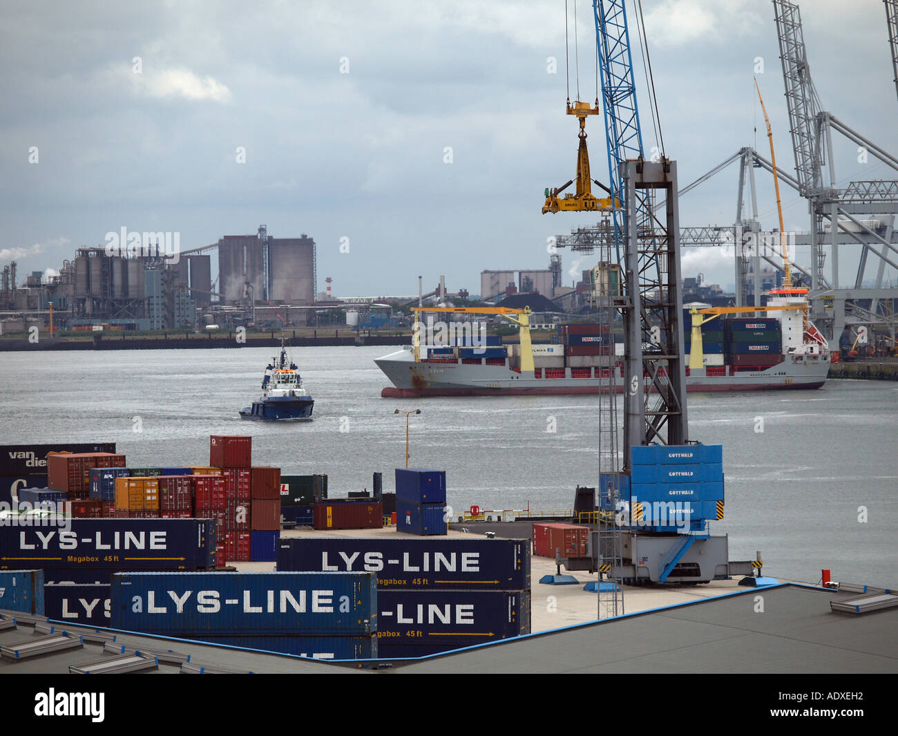 Sea port of Rotterdam with coaster loaded with container cargo and tug ...