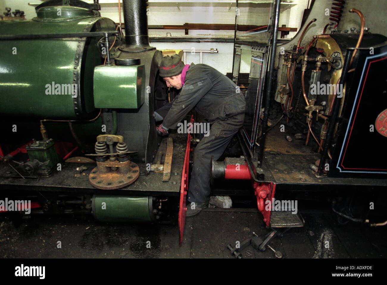 Engineer working on the boiler of a steam engine at Bala Lake Railway ...