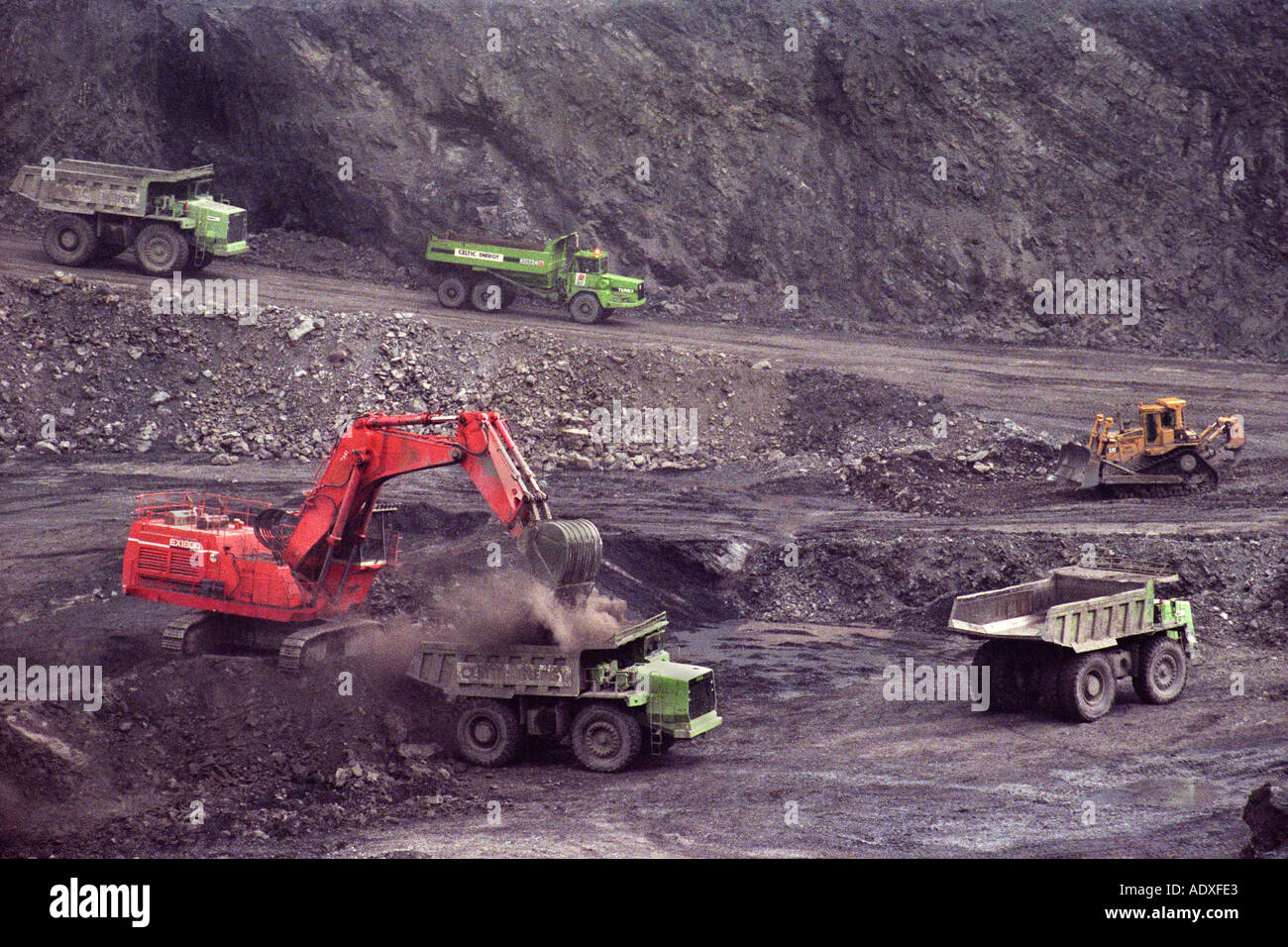 Mechanical shovel and tipper trucks working in opencast coal mine in ...