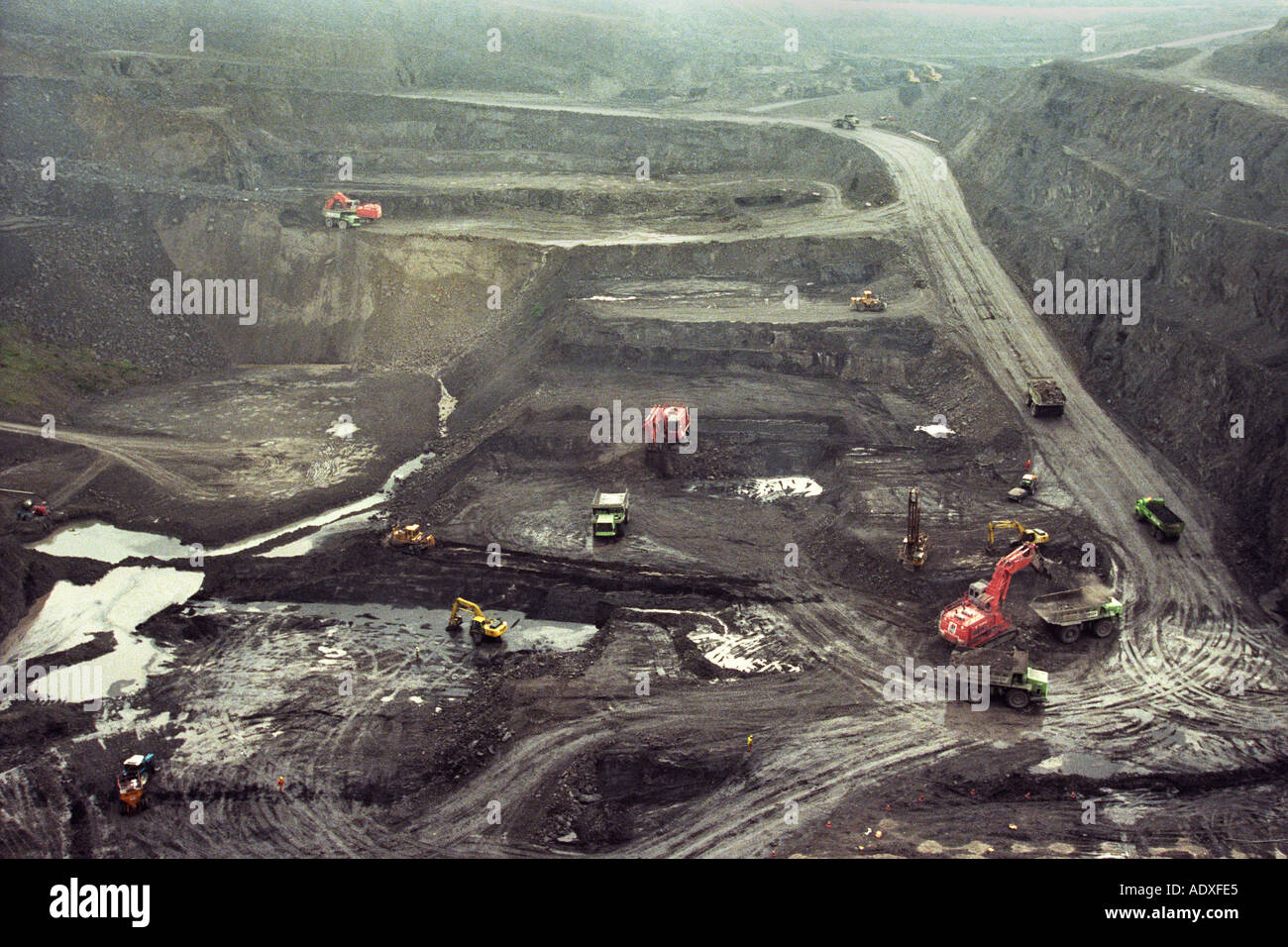 Mechanical shovel and tipper trucks working in opencast coal mine in ...
