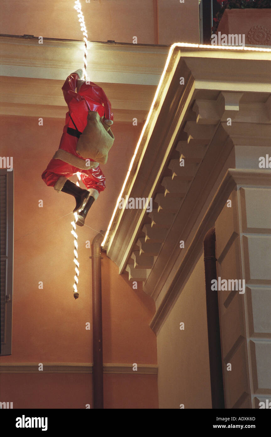 life size father christmas model climbing side of house Stock Photo - Alamy