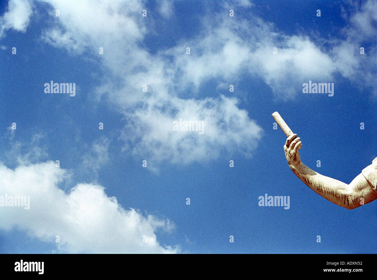 male statue s hand reaching out with baton and blue sky Stock Photo - Alamy