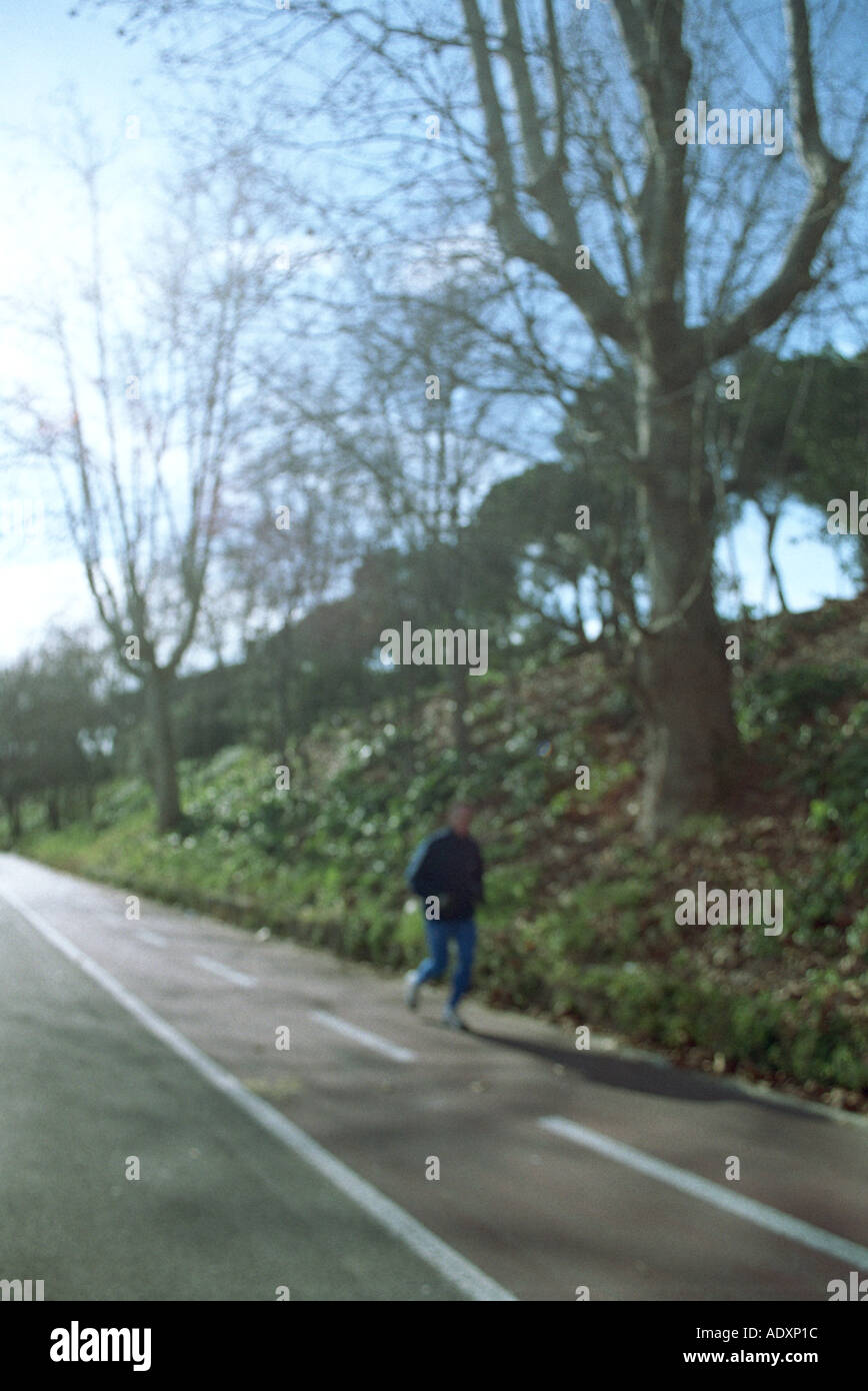 man walking along tree covered cycle path Stock Photo - Alamy